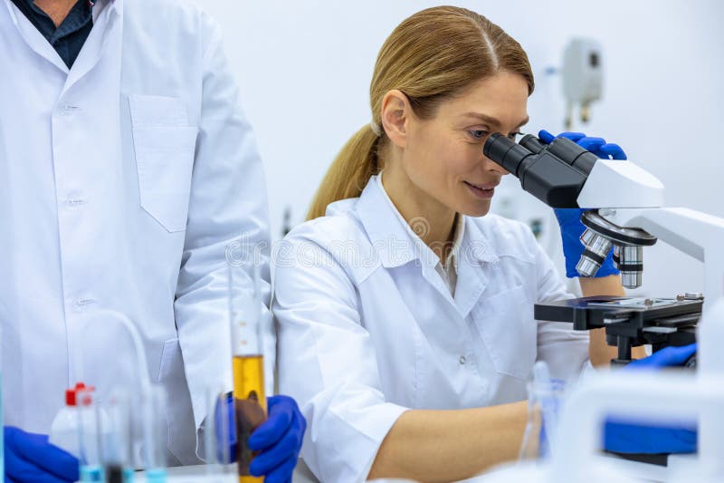 Medical Female Scientist Looking Under Microscope, Doing Analysis of ...
