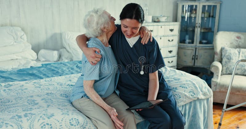 Medical Hugging And Nurse With Senior Woman At A Consultation In