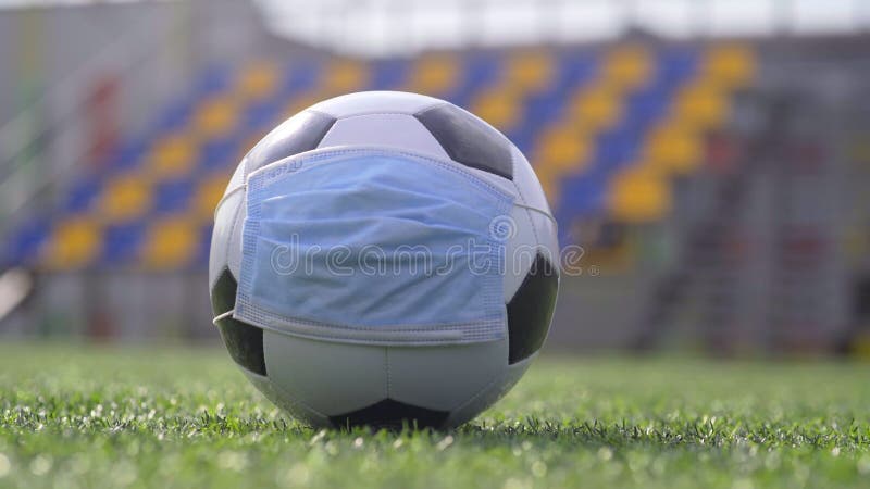 Coronavirus Pandemic Concept. Soccer Ball in Medical Mask at Empty ...