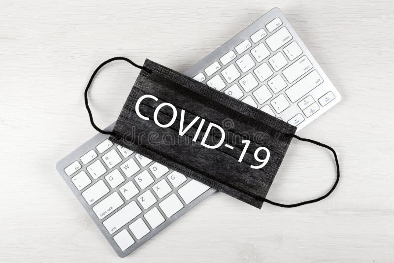 Medical Mask with Inscription Covid-19 on the Pc Keyboard on the Table ...