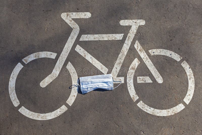 The Medical Mask is Lying on the Asphalt at the Sign of the Bike Path ...