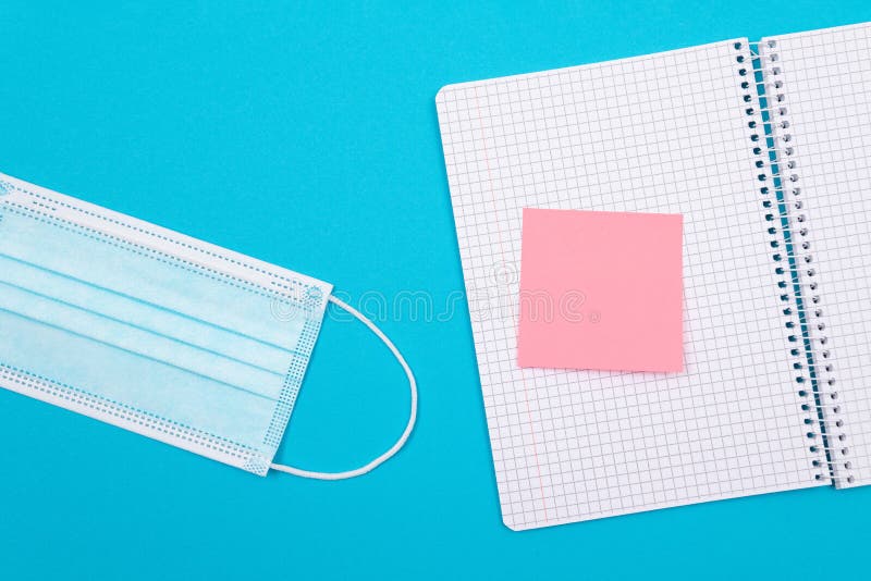 A Medical Mask and a Note Pad Lying on Blue Table Stock Photo - Image ...