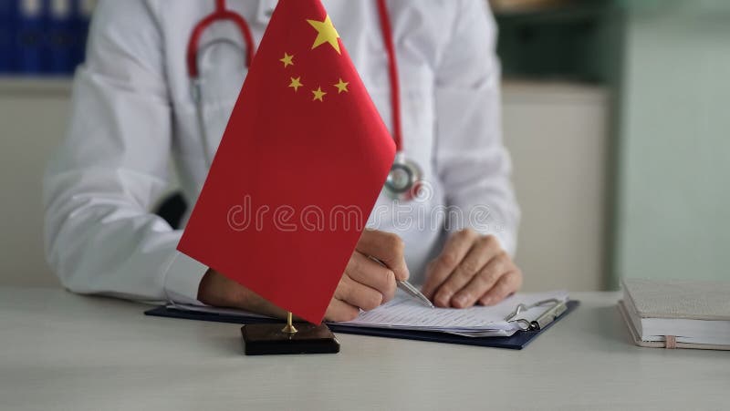 Medical Professional Taking Notes with a Chinese Flag Displayed Stock ...