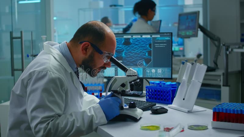 Man Research Scientist Looking at Samples Under Microscope Stock ...