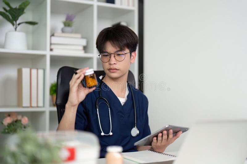 Medical Student Analyzing Medication while Using a Tablet at a Desk ...