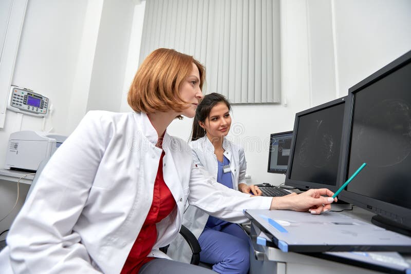Medical Team Discussing Around a Computer Stock Photo - Image of nurse ...