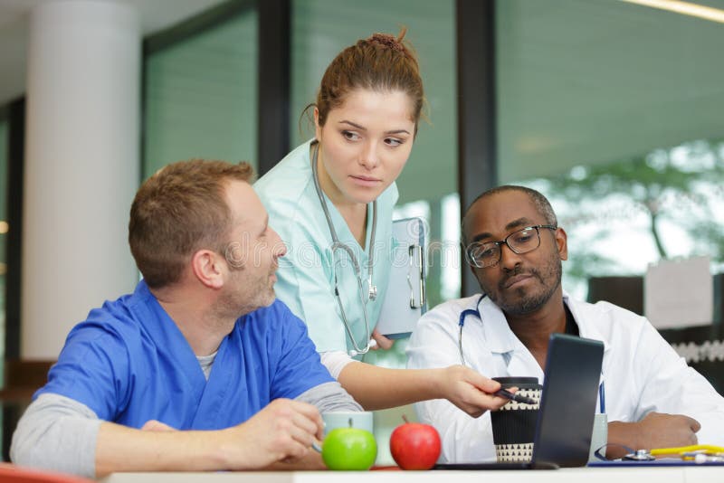 Medical Team Interacting at Hospital Stock Photo - Image of notebook ...