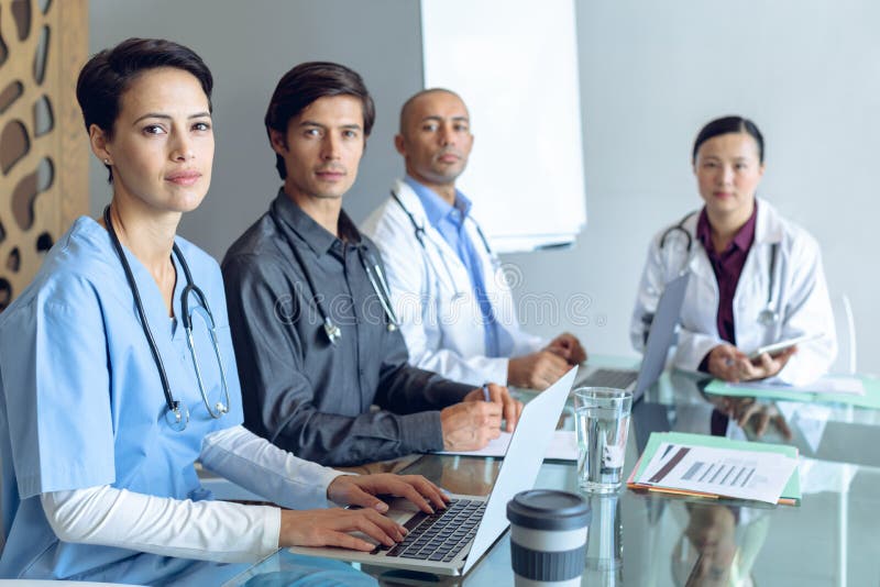 Medical Team Looking at Camera while Sitting at Table in Hospital Stock ...