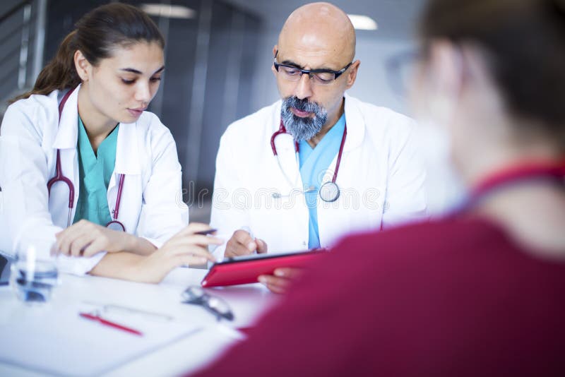 Medical Team Sitting and Discussing at Table Stock Image - Image of ...