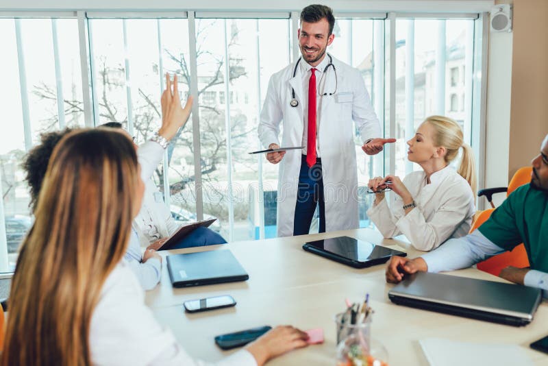 Medical Team Sitting and Discussing at the Table Stock Image - Image of ...