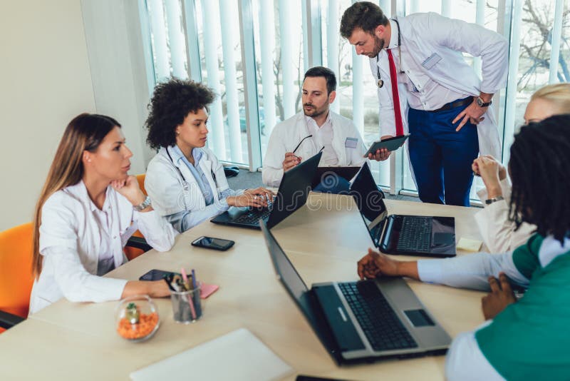 Medical Team Sitting and Discussing at the Table Stock Photo - Image of ...