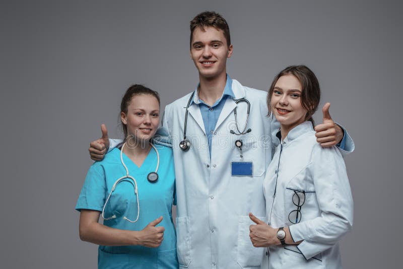 Medical Team of Three People Dressed in Uniform Isolated on Gray Stock ... Medical Team of Three People Dressed in Uniform Isolated on Gray Stock ...