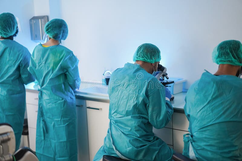 Medical Workers Using Microscope and Working Inside Hospital Lab ...