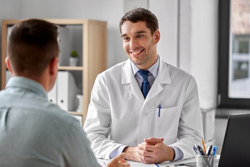 Smiling Doctor Talking To Male Patient at Hospital Stock Image - Image ... Smiling Doctor Talking To Male Patient at Hospital Stock Image - Image ...