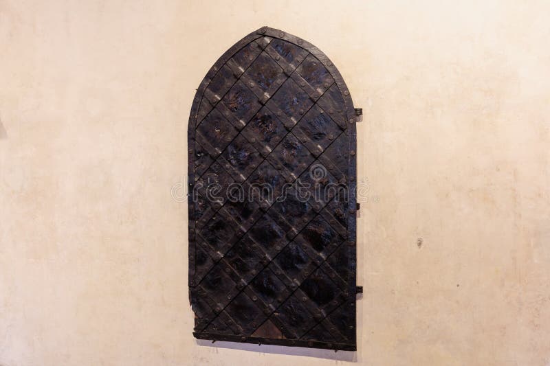 Medieval Arched Metal Door with Diamond Pattern on Stone Wall Stock ...