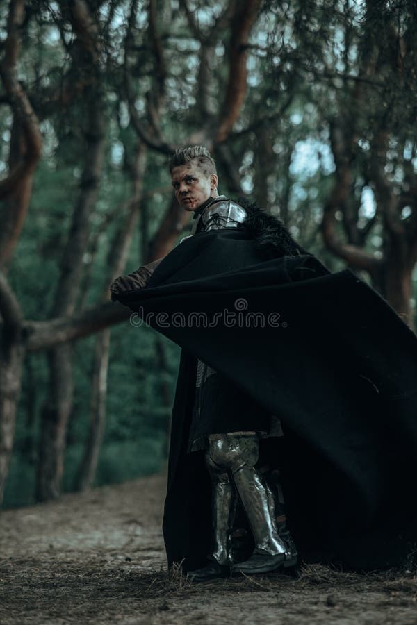 Medieval Knight in Armour and Black Cape Stands in Forest Stock Photo ...