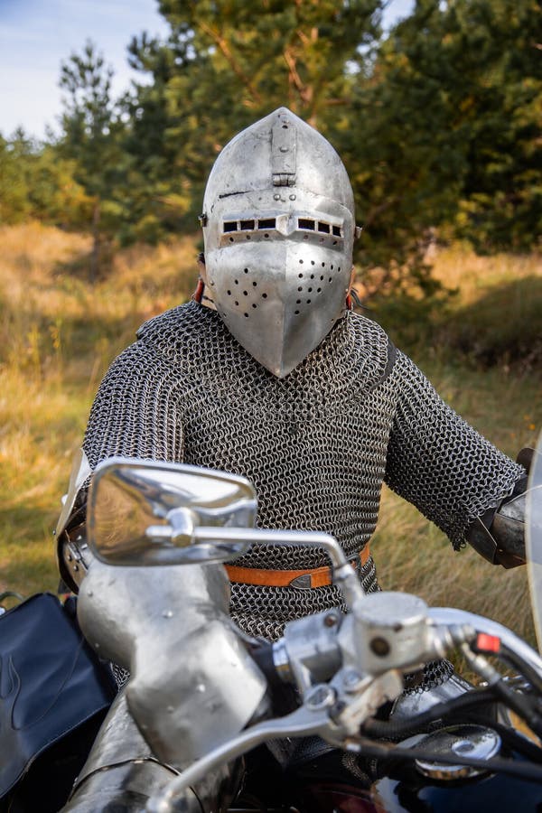 A Medieval Knight in Chain Mail and a Helmet Sits on a Motorcycle ...