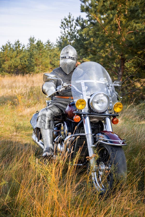 A Medieval Knight in Chain Mail and a Helmet Sits on a Motorcycle ...