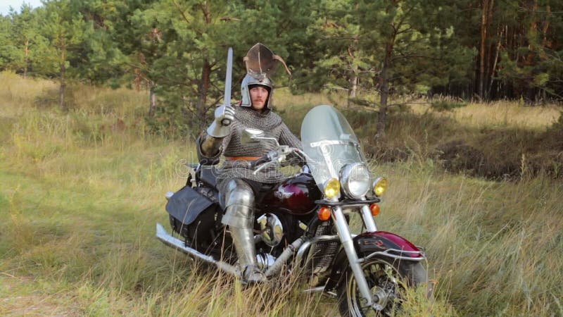A Medieval Knight in Full Armor Sits on a Motorcycle Against the ...