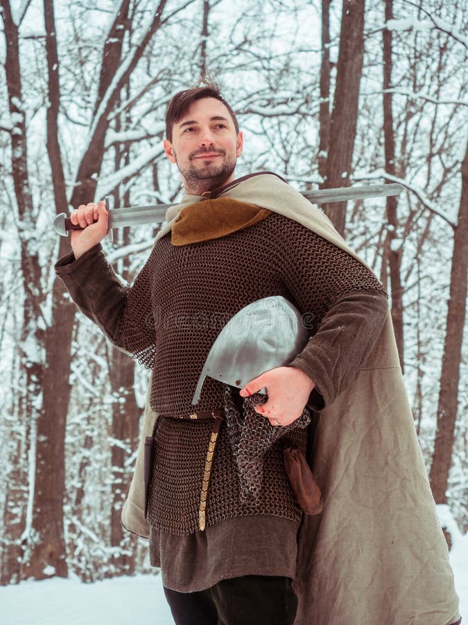 Medieval Viking Warrior in Chain Mail and Helmet Holds a Sword in the ...