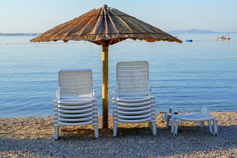 Mediterranean Coast with Sunbeds and Straw Sun Umbrellas on the Sandy ...