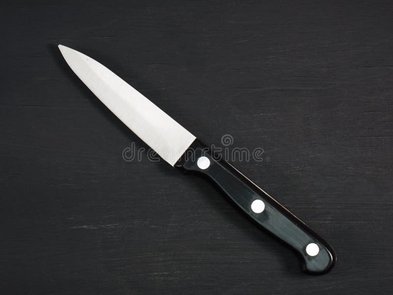 Medium Sharp Kitchen Knife with Black Handle on a Black Wooden Board ...