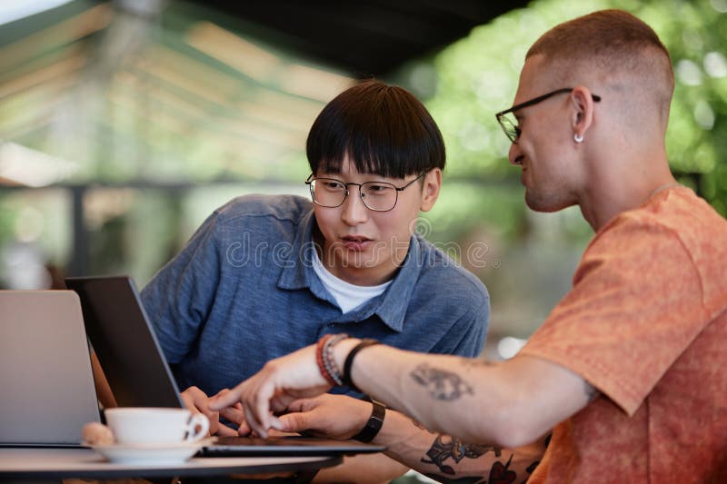Male it Developer Looking at Laptop Screen Working with Colleague while ...