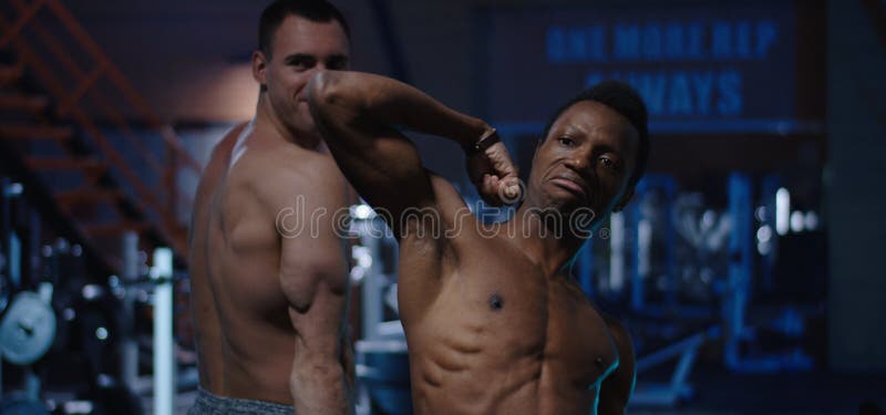 Body Builder and Regular Man Showing Muscles Stock Photo - Image of ...