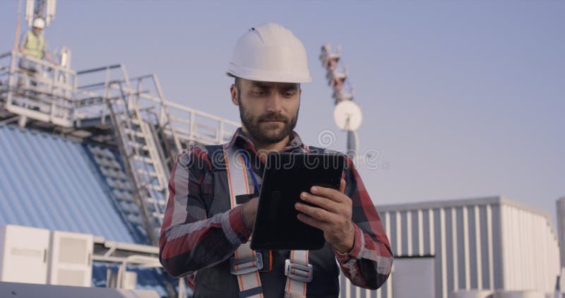 Engineers Using a Tablet on a Cellular Tower Stock Image - Image of ...