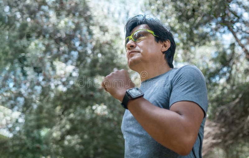 Medium Shot of Latin Man Running in a Forest with Glasses and Smart ...