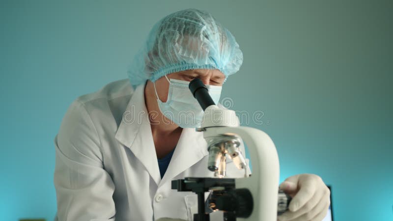 Medium Shot of Middle-aged Medical Worker Looking in Microscope in ...