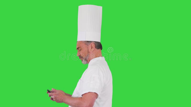 Senior Chef in Uniform Using Mobile Phone on a Green Screen, Chroma Key ...