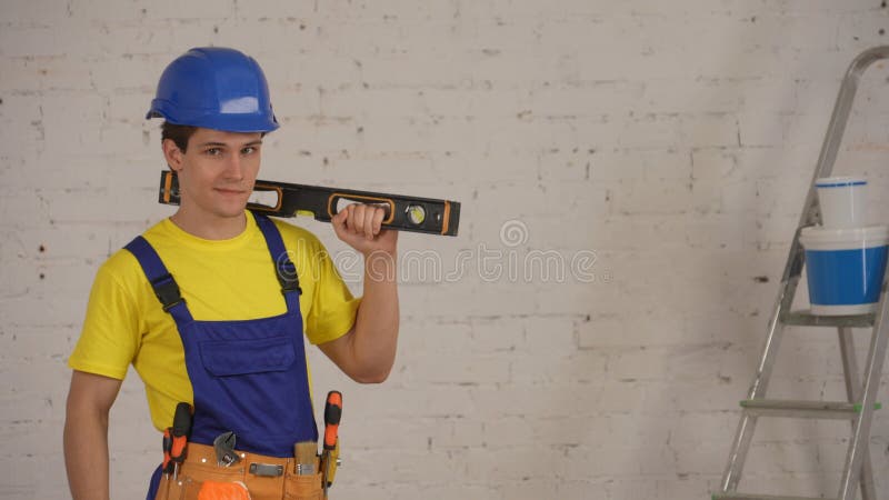 Medium Shot of a Smiling Young Construction Worker Wearing a Tool Belt ...