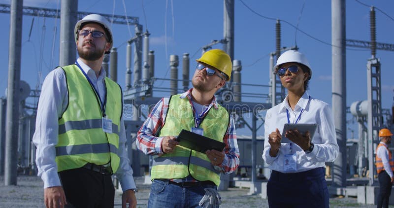 Three Electrical Workers Reviewing Documents on a Tablet Stock Photo ...