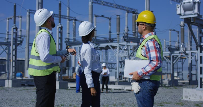 Three Electrical Workers Reviewing Documents on a Tablet Stock Image ...