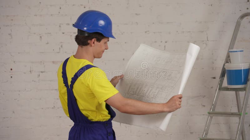 Medium Video of a Smiling Young Construction Worker Looking at the Plan ...