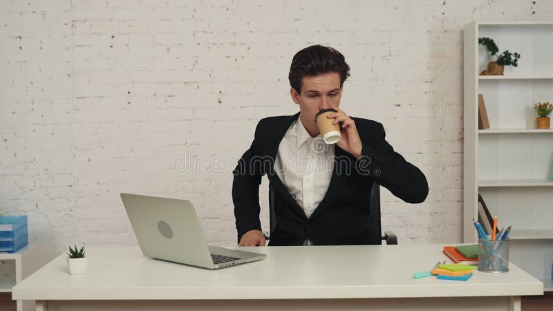 Medium Video of a Young Man Sitting at the Table in Front of the Laptop ...