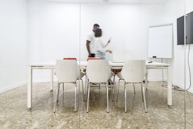 Meeting Room with People on the Move with White Table and Chairs in ...