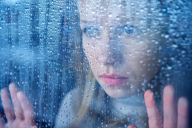 Beautiful Young Woman Sitting Alone Close To Window With Rain Drops