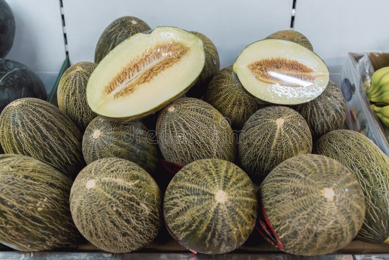 A Melon Split in Half on a Pile of Melons Stock Photo - Image of ...