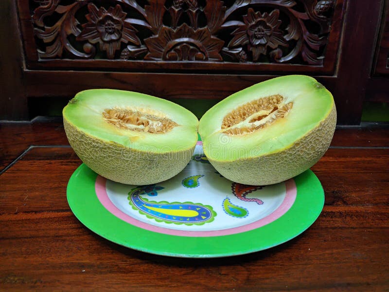 A Melon Split in Half on a Pile of Melons Stock Photo - Image of ...