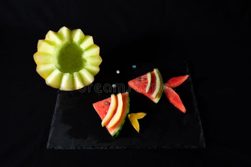 Melon and Watermelon in the Shape of a Fish, on a Black Background ...
