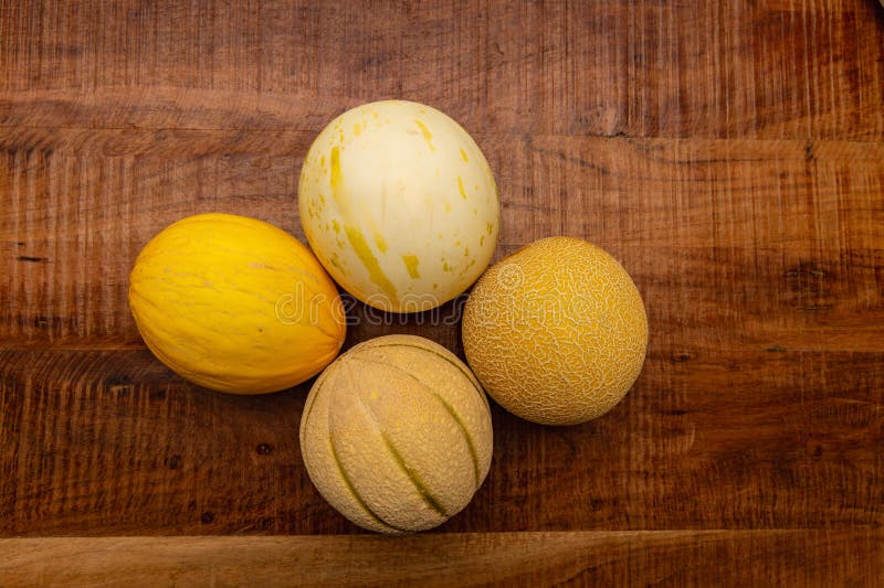 Melons of Four Different Varieties Lying on a Rustic Wooden Table Stock ...