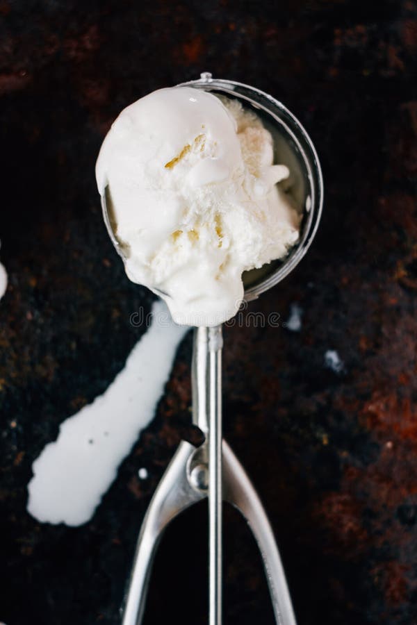 Melted Ice Cream in Metal Ice Cream Scooper Over Black Rustic Table ...
