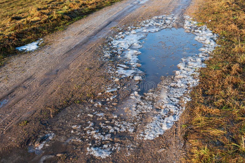 Melting Ice and Puddle on a Country Road in Winter Day Stock Photo ...