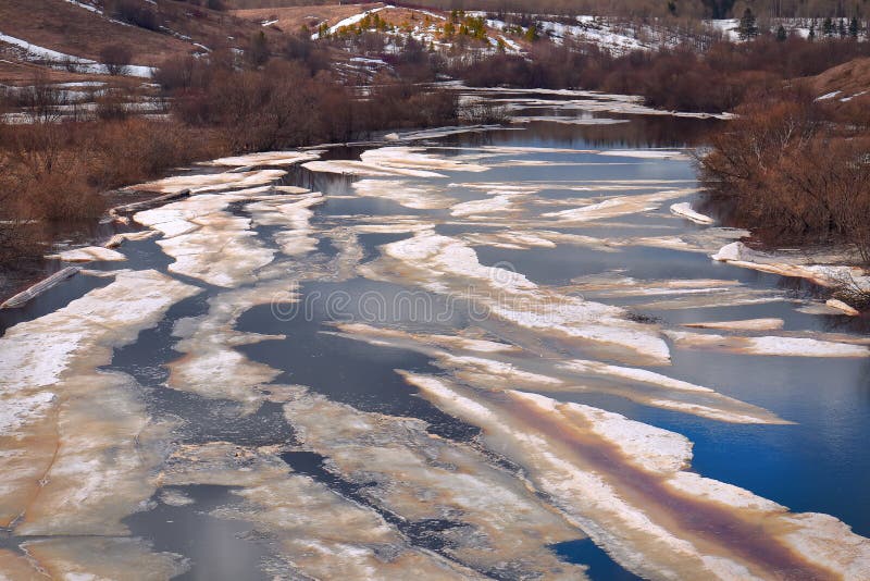 Melting Ice on a River in a Hilly Area with Trees Stock Photo - Image ...