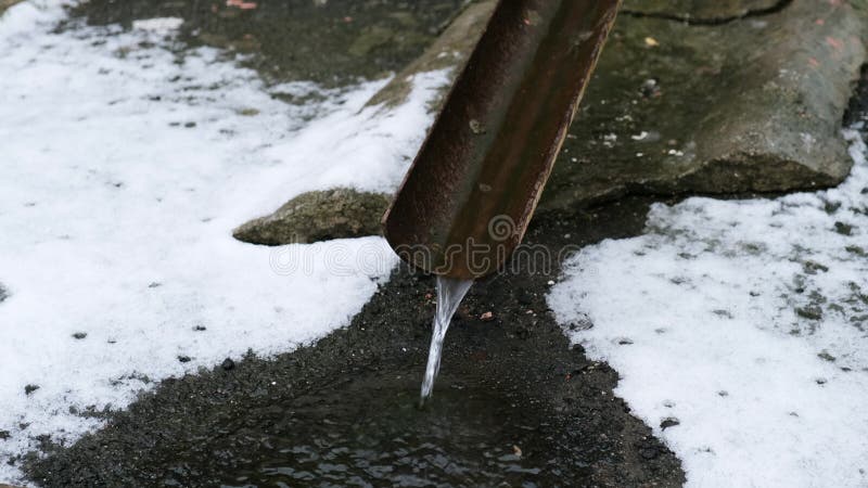 Meltwater Flows through a Storm Drain Pipe . Concept of the Onset of ...