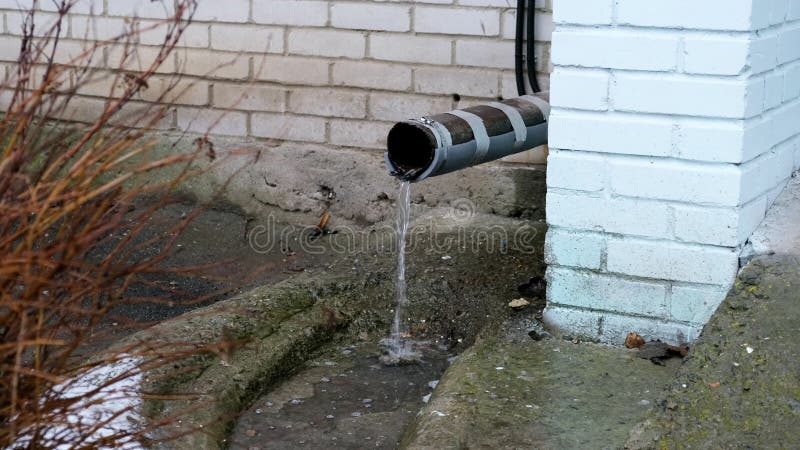 Meltwater Flows through a Storm Drain Pipe . Concept of the Onset of ...