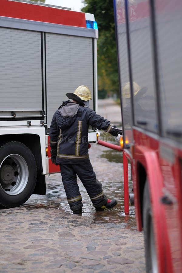 A Member of the Fire Brigade Holds a Water Supply Hose Stock Photo ...