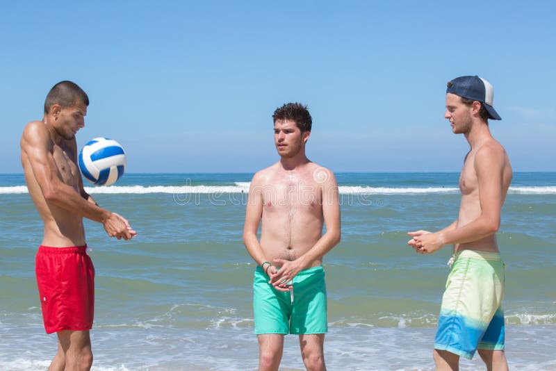 Men on Beach Playing with Ball Stock Photo - Image of beach, three ...